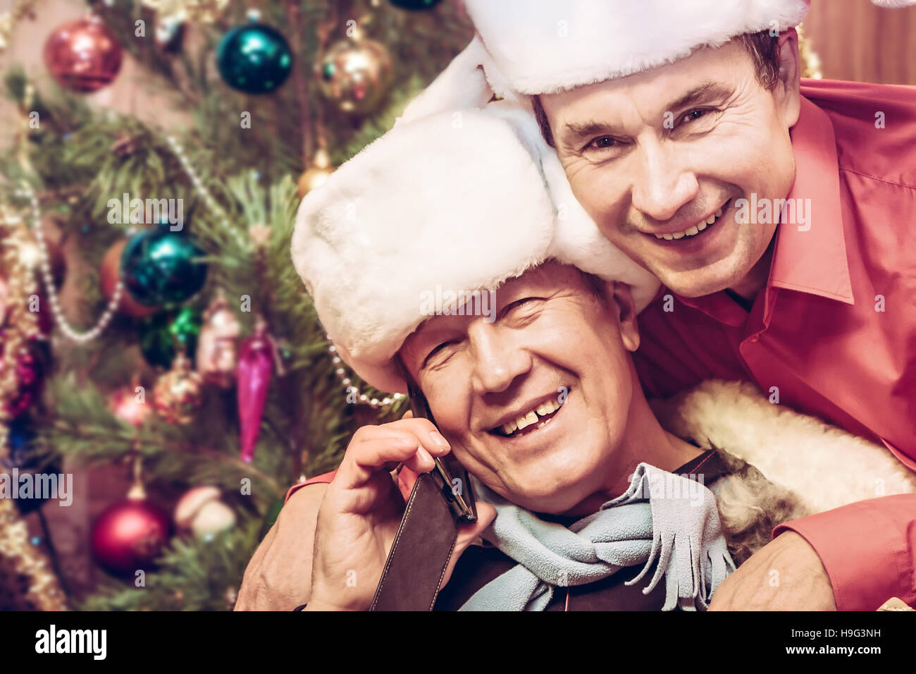 Cheerful senior men greeting you with Christmas and New Year holidays ...