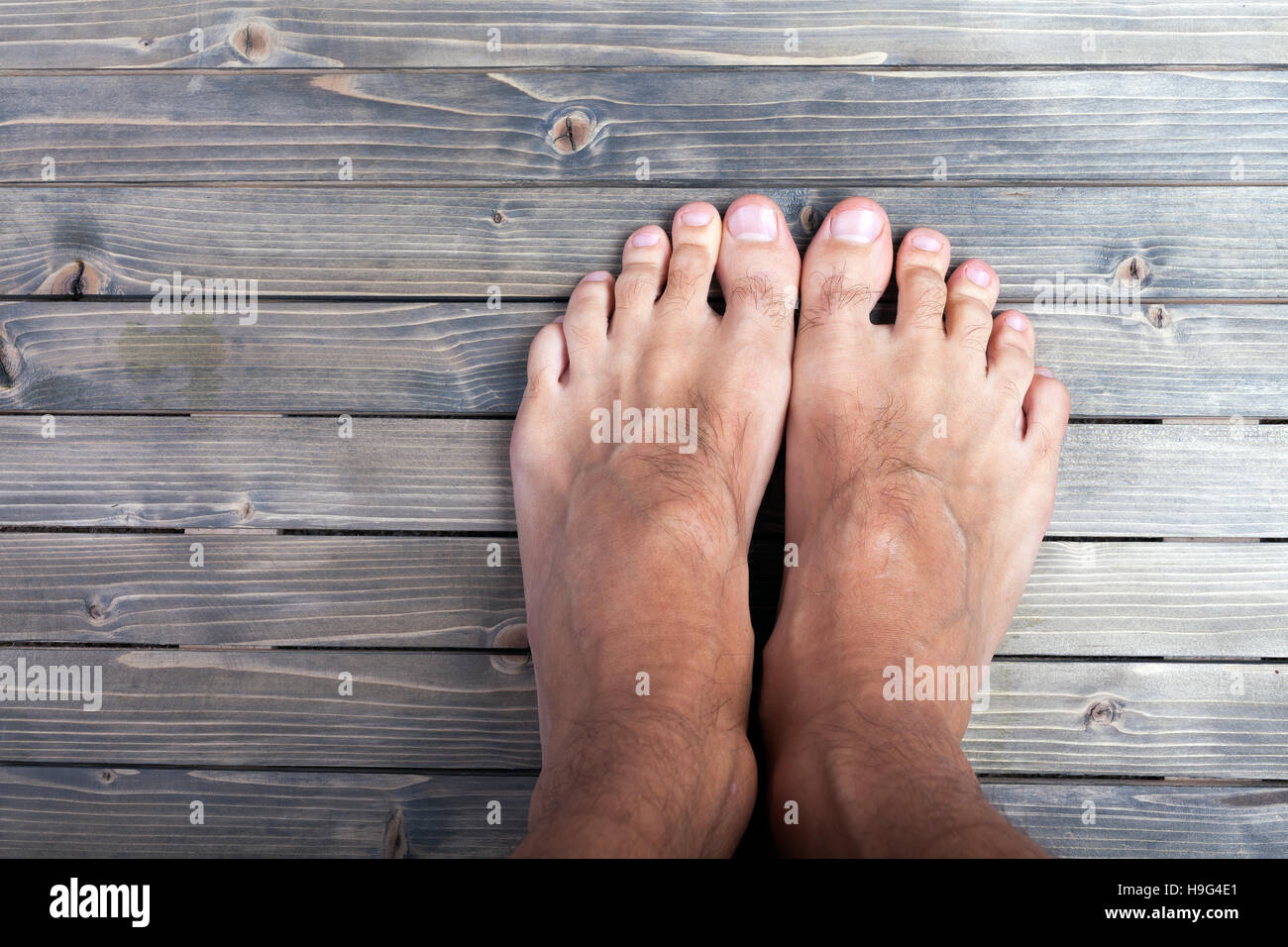 male feet on wooden background Stock Photo - Alamy