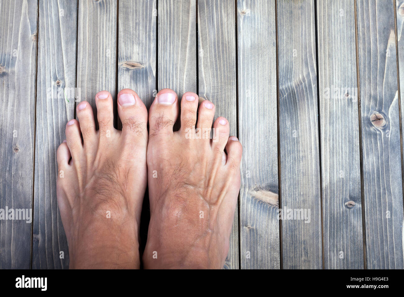 male feet on wooden background Stock Photo - Alamy