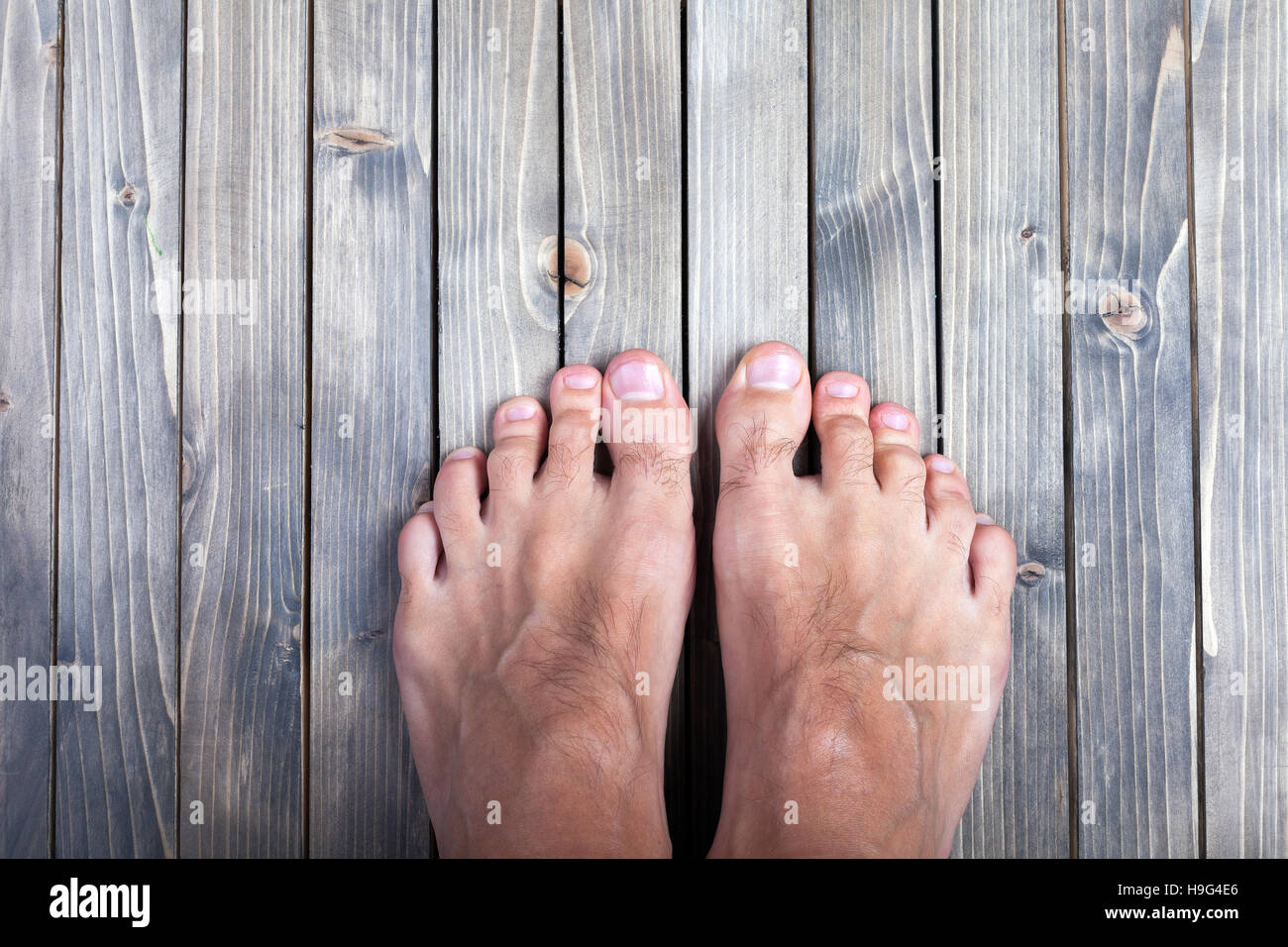 male feet on wooden background Stock Photo - Alamy