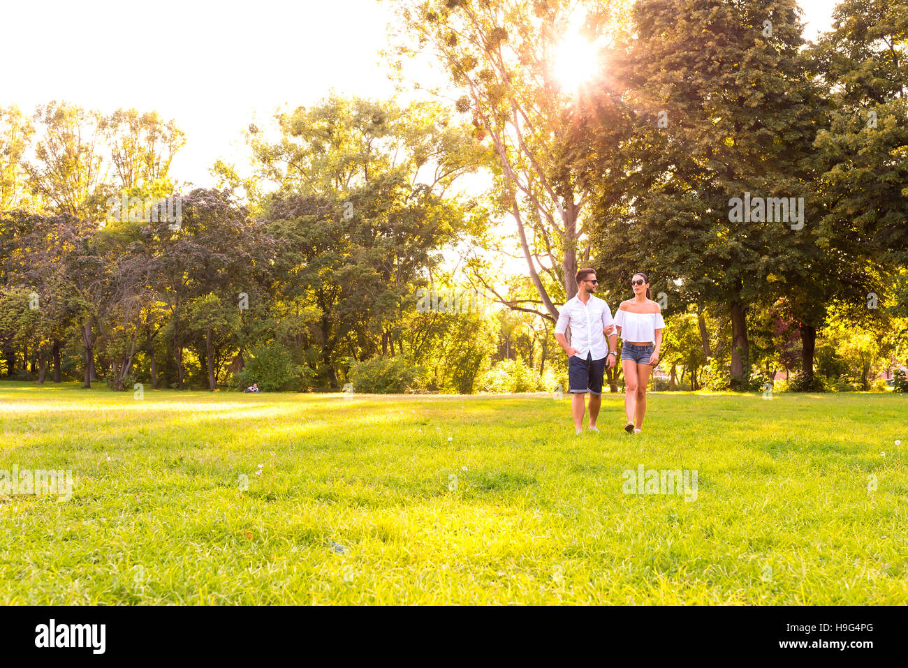 A beautiful young european couple having a walk together in a park in ...