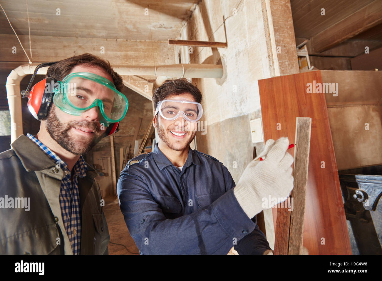 Two carpenters cooperating with each other and working Stock Photo - Alamy