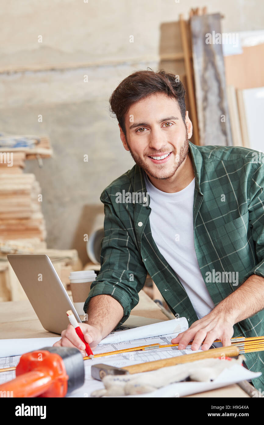 Carpenter with floorplan at workbench Stock Photo - Alamy