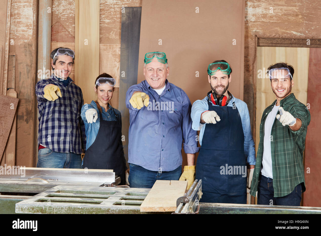 Team of carpenters pointing to camera with joy as motivation Stock ...