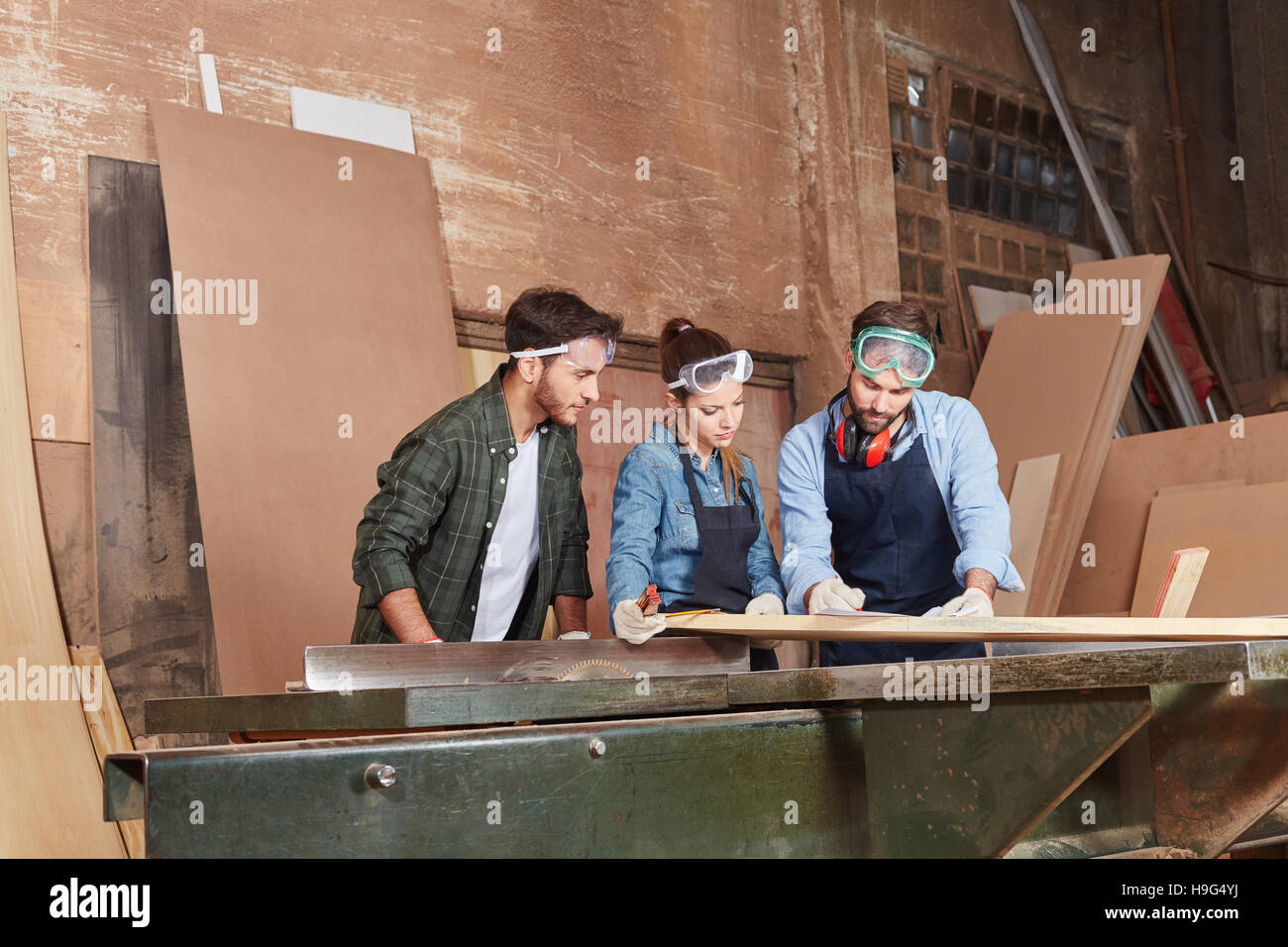 Carpenters cooperating and looking at floorplan during carpentry's ...