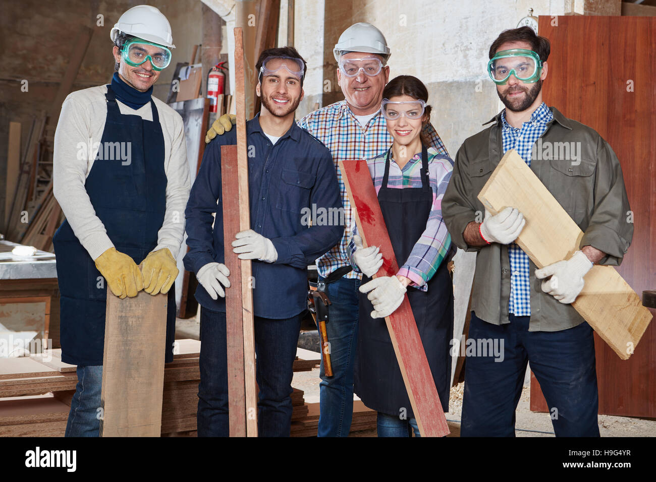 Carpenters team holding wood at workshop Stock Photo - Alamy