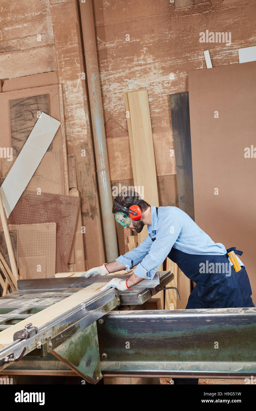 Carpenter working with saw and processing wood Stock Photo - Alamy