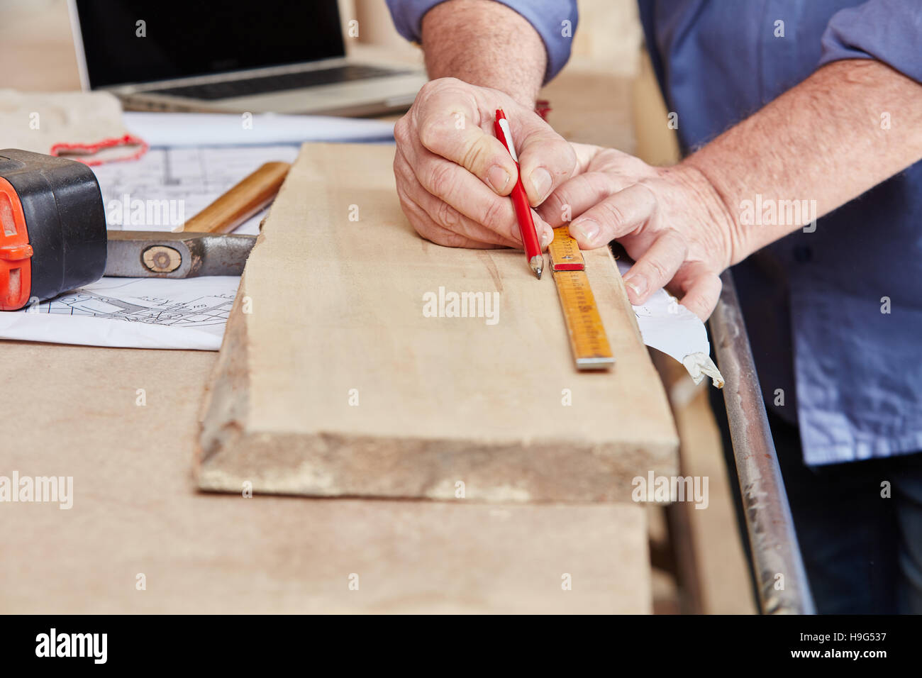 Carpenter measuring wood board with pen and ruler Stock Photo - Alamy