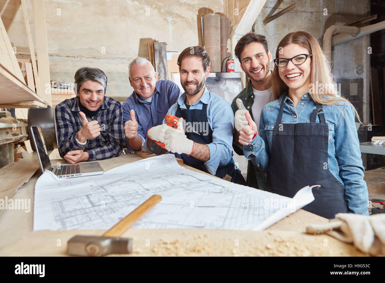 Carpenters team holding thumbs up for motivation Stock Photo - Alamy