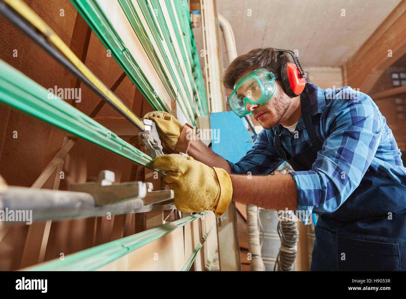 Man working with vertical saw machine with competence Stock Photo - Alamy