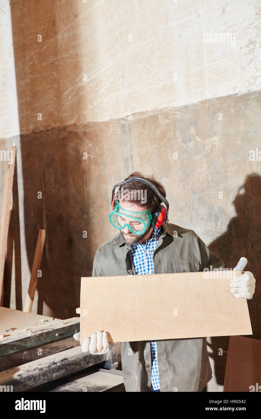Carpenter woodworking with board at carpentry shop Stock Photo - Alamy
