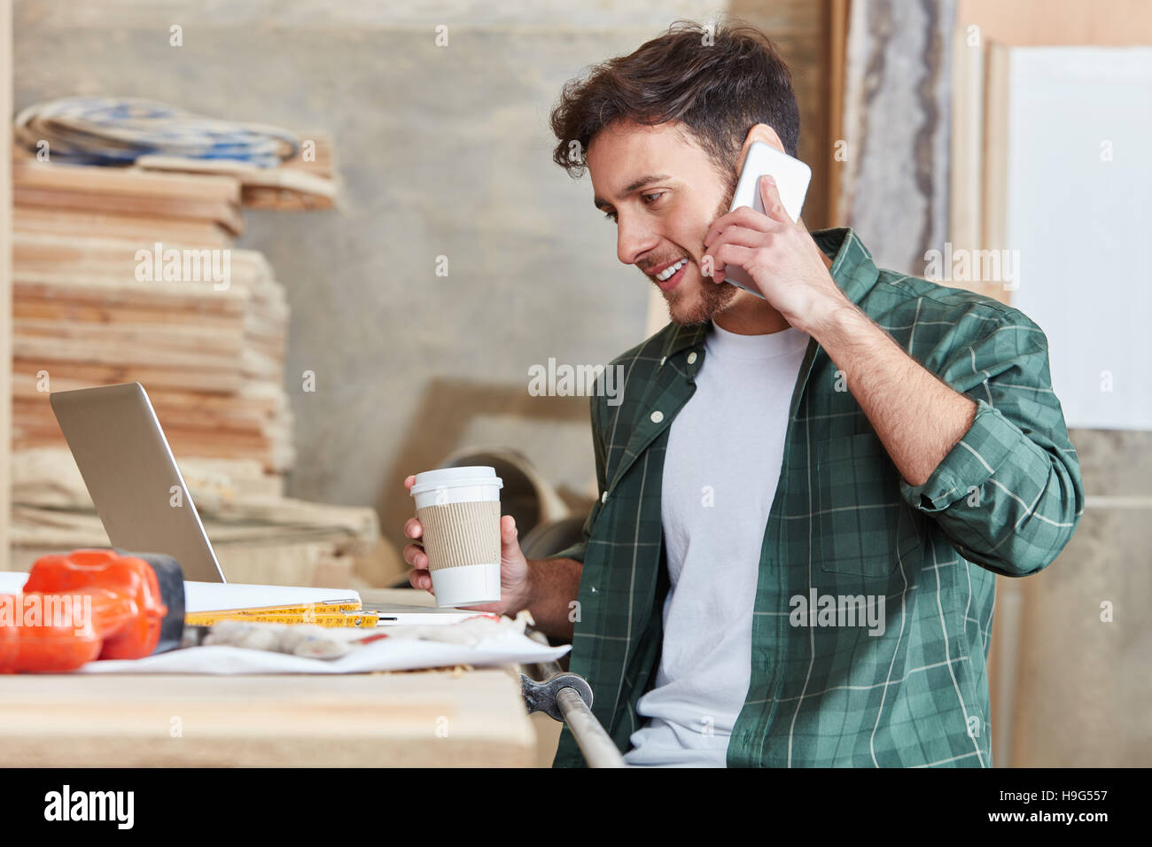 Man at workshop servicing with mobile phone Stock Photo - Alamy