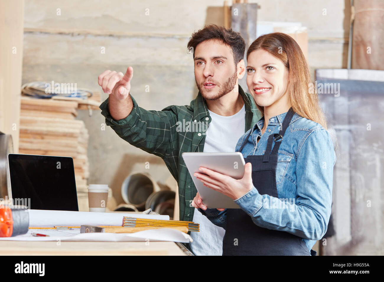 Carpenter and student with tablet computer at workshop Stock Photo - Alamy