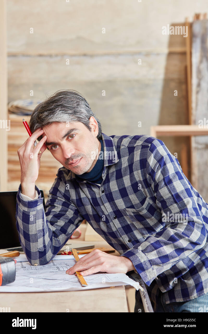 Craftsman thinking concentrated about an architectural drawing problem ...