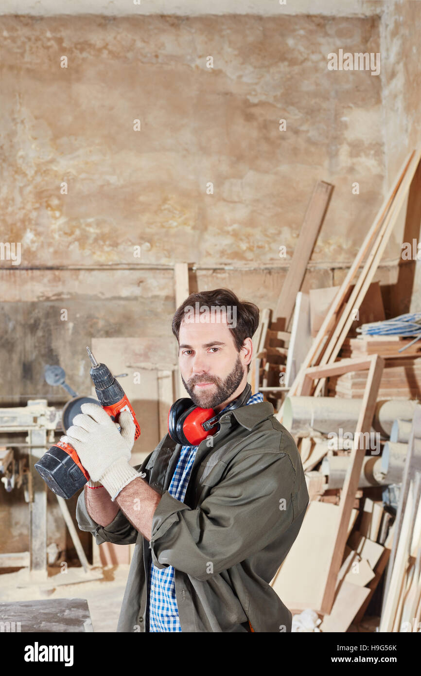 Craftsman as carpenter with drilling machine tool Stock Photo - Alamy