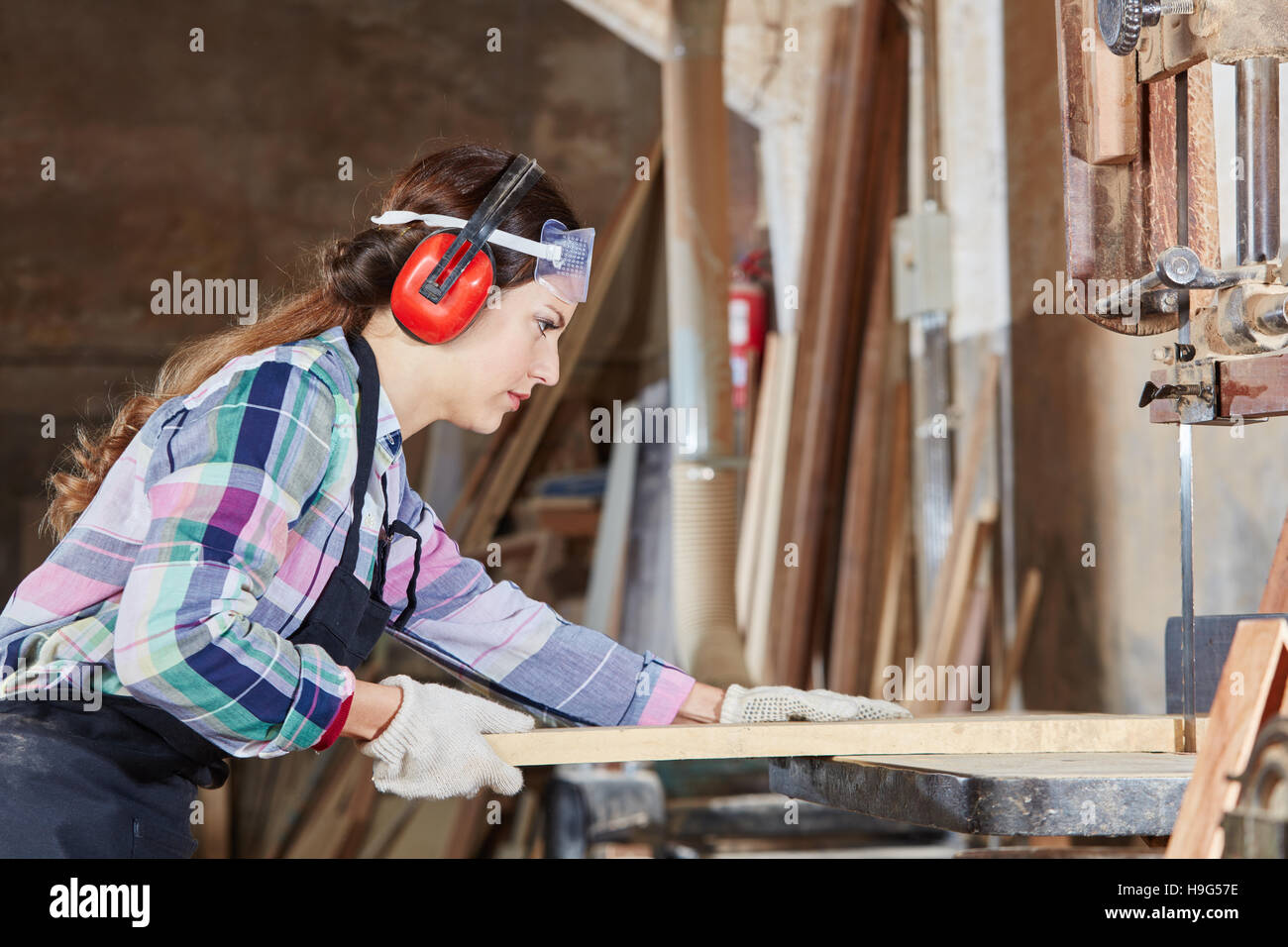 Woman during carpentry apprenticeship working with saw Stock Photo - Alamy