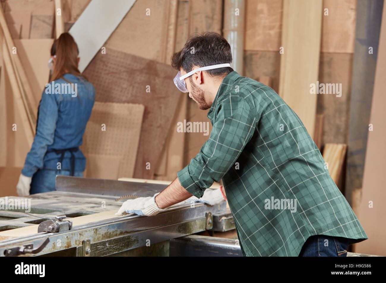 Craftsman as carpenter working with circular saw Stock Photo - Alamy