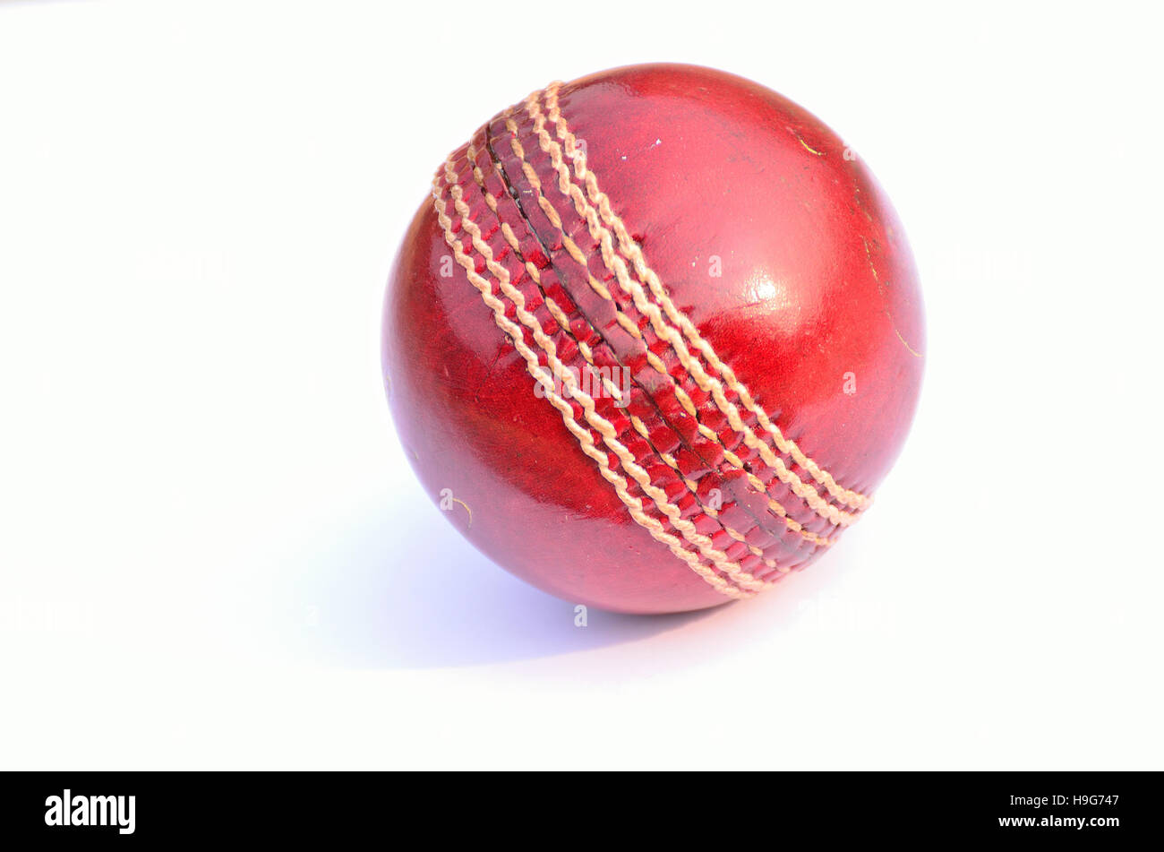 Cricket ball with a shadow on a white background Stock Photo - Alamy
