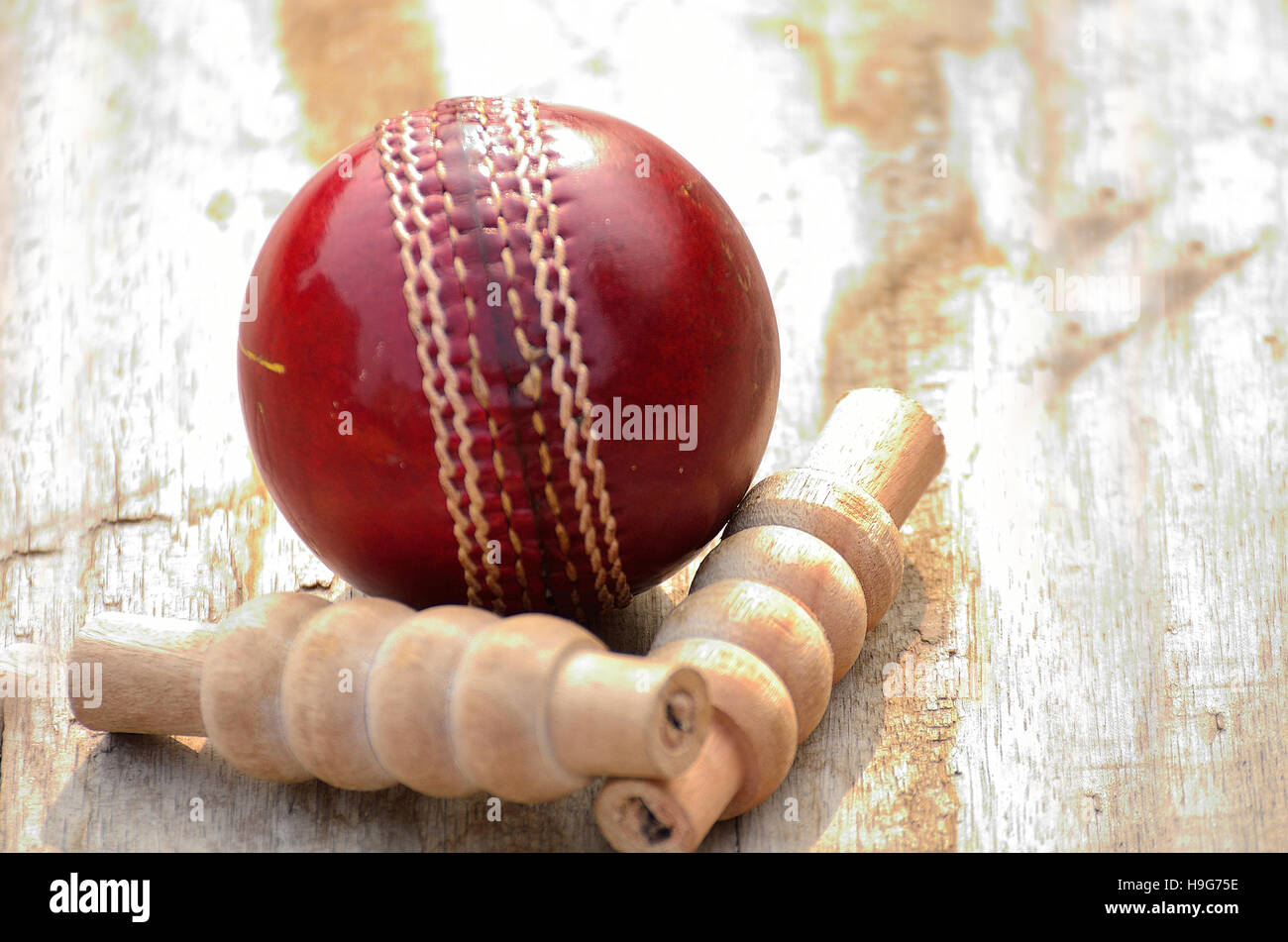 Cricket ball and bails with a shadow on a wooden background Stock Photo ...