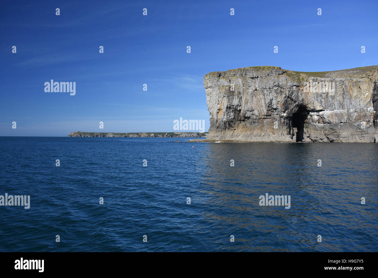 A hole through the rocks on the coast at Stackpole Head with St. Govan ...