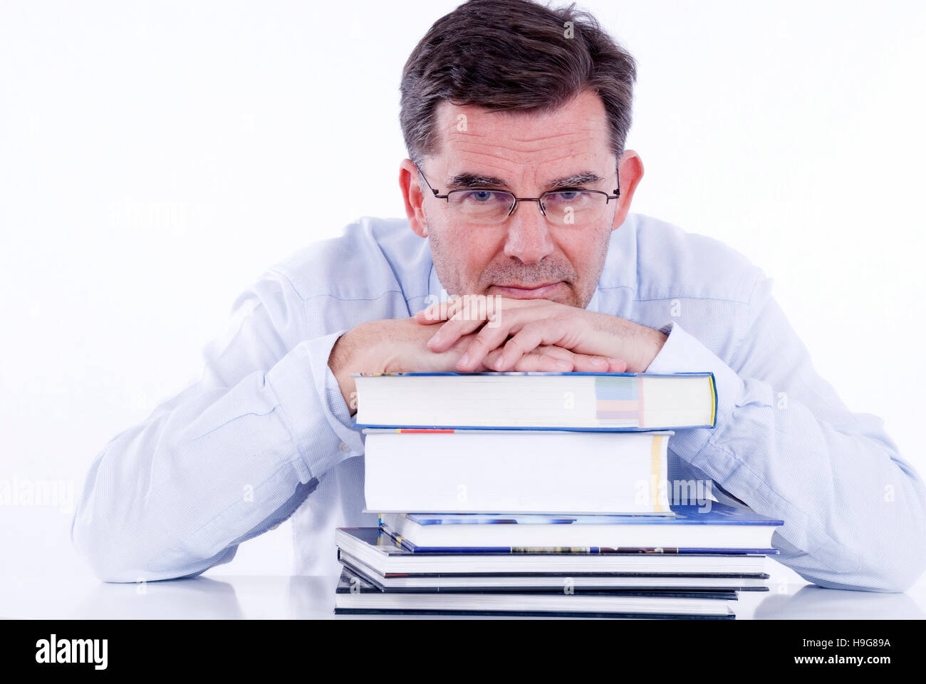 Man, 50+, leaning on a stack of books Stock Photo - Alamy