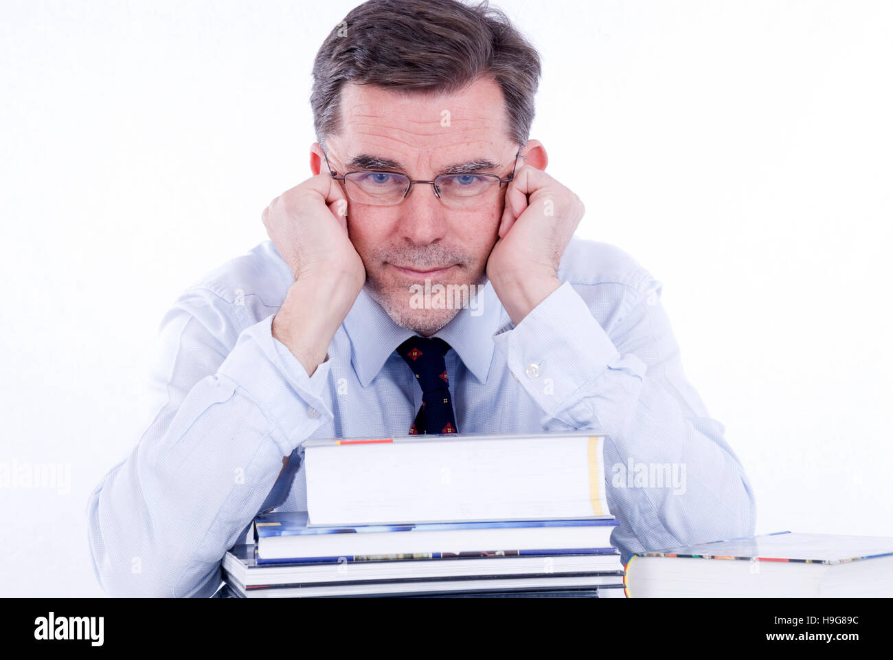 Man, 50+, leaning on a stack of books Stock Photo - Alamy