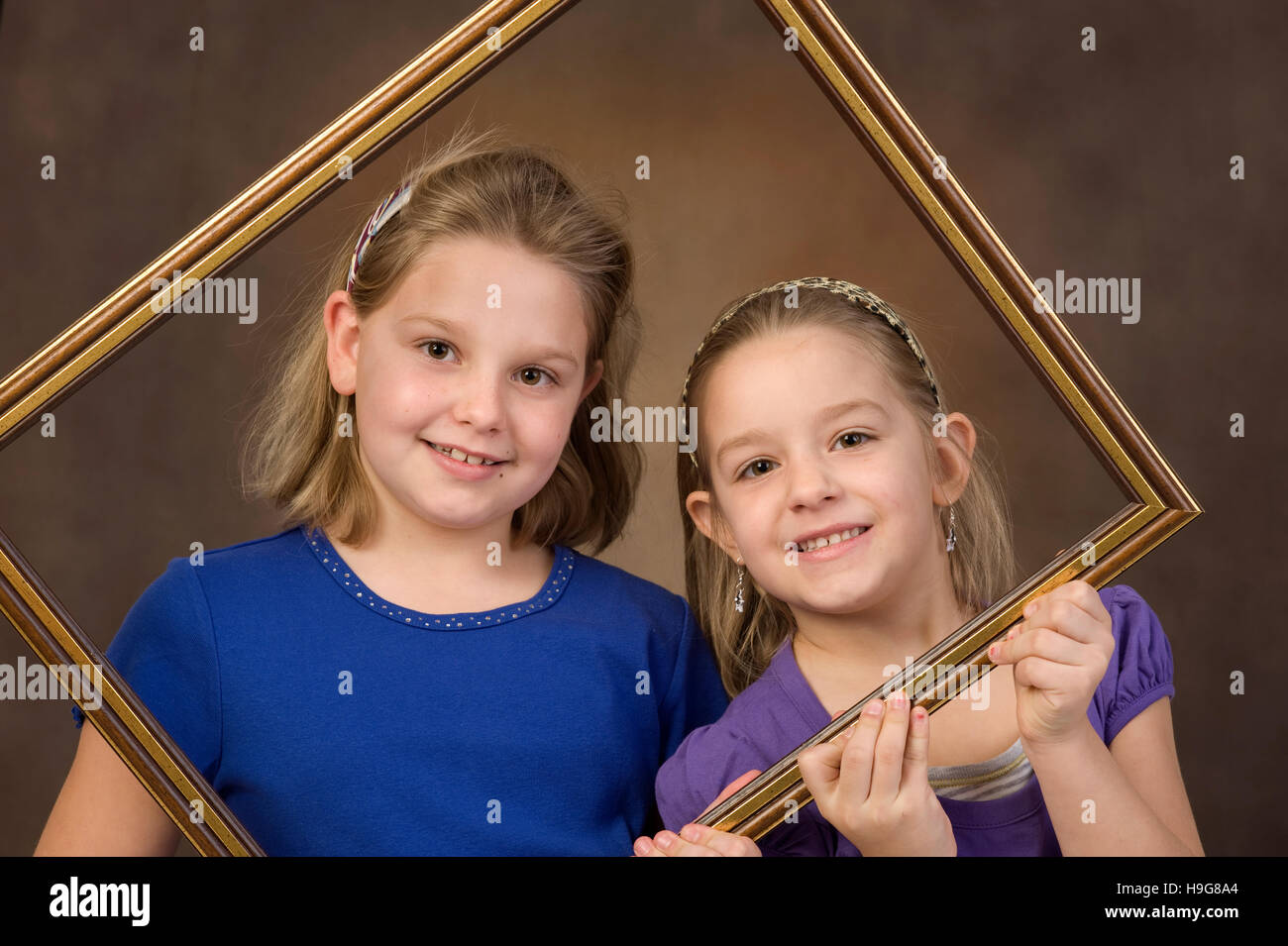 Two girls in a picture frame Stock Photo - Alamy