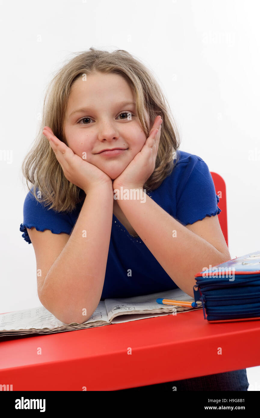 Schoolgirl, 8 years old, sitting at a desk Stock Photo - Alamy