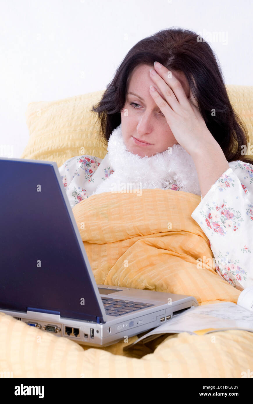 Sick young woman in bed, working on a laptop Stock Photo - Alamy
