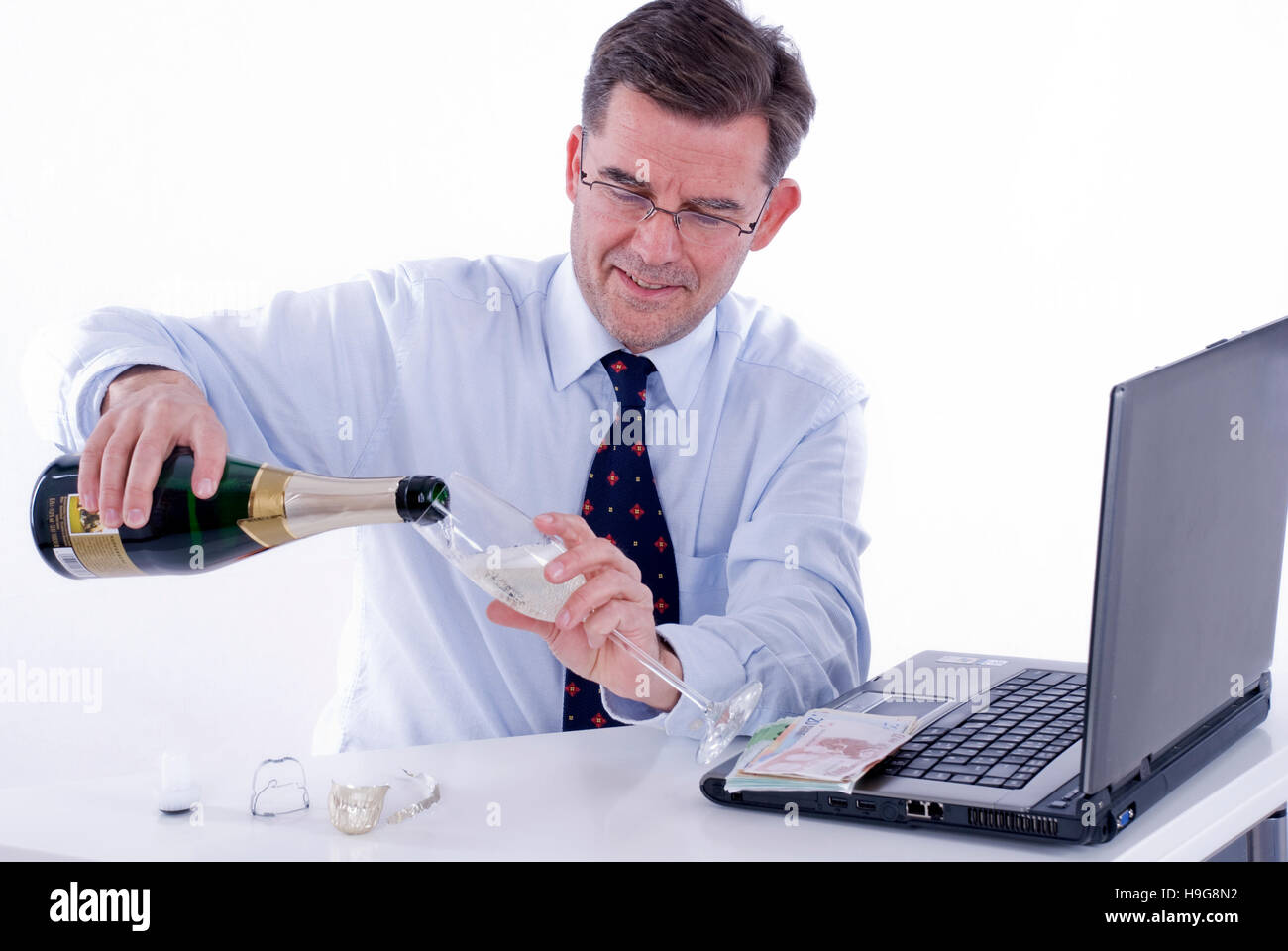 Businessman drinking sparkling wine in the office Stock Photo - Alamy
