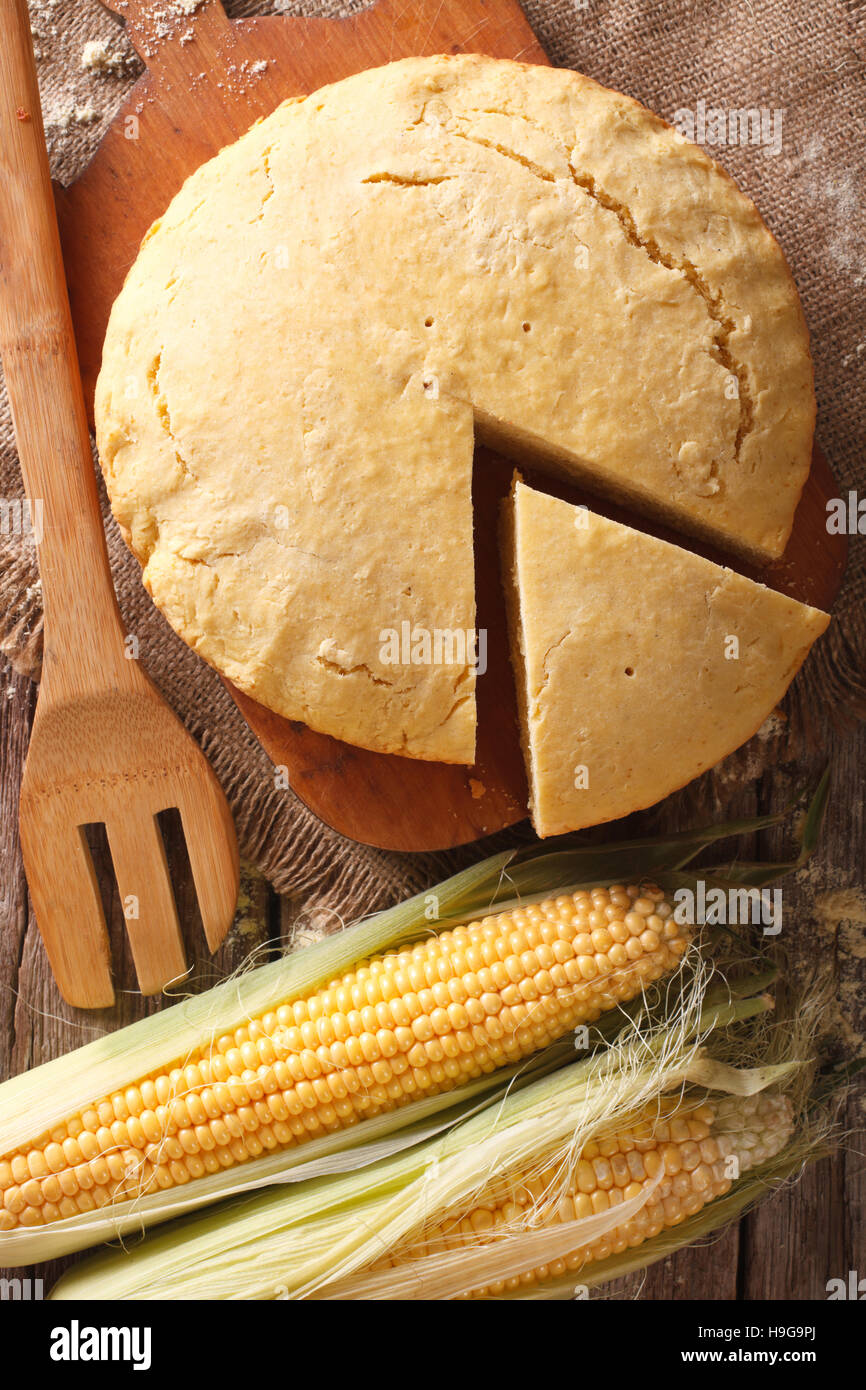 Round loaf of corn bread close-up on a wooden board. vertical view from ...