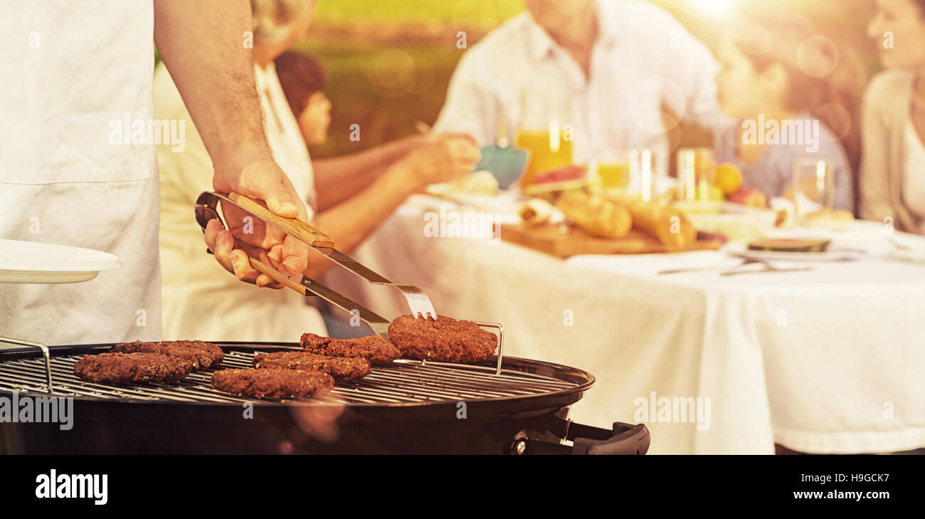 Barbecue grill with extended family having lunch in park Stock Photo ...