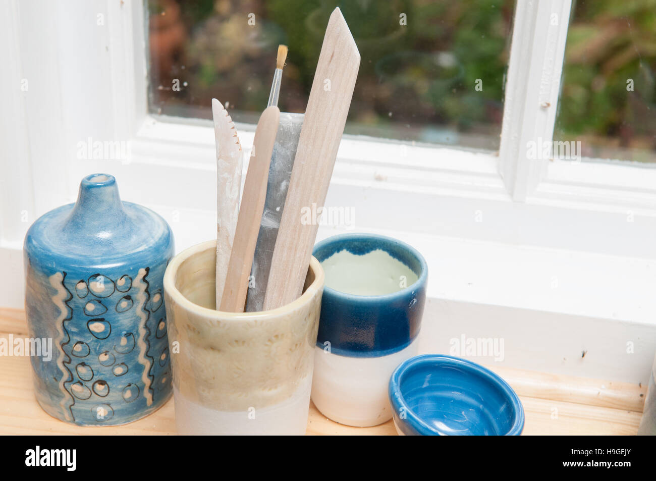 Pottery tools and vases on a window ledge in daylight Stock Photo - Alamy