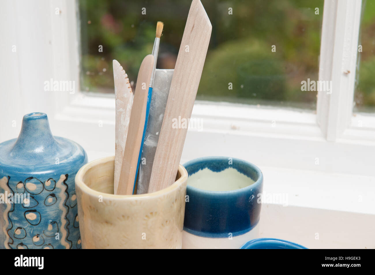 Pottery tools and vases on a window ledge in daylight Stock Photo - Alamy