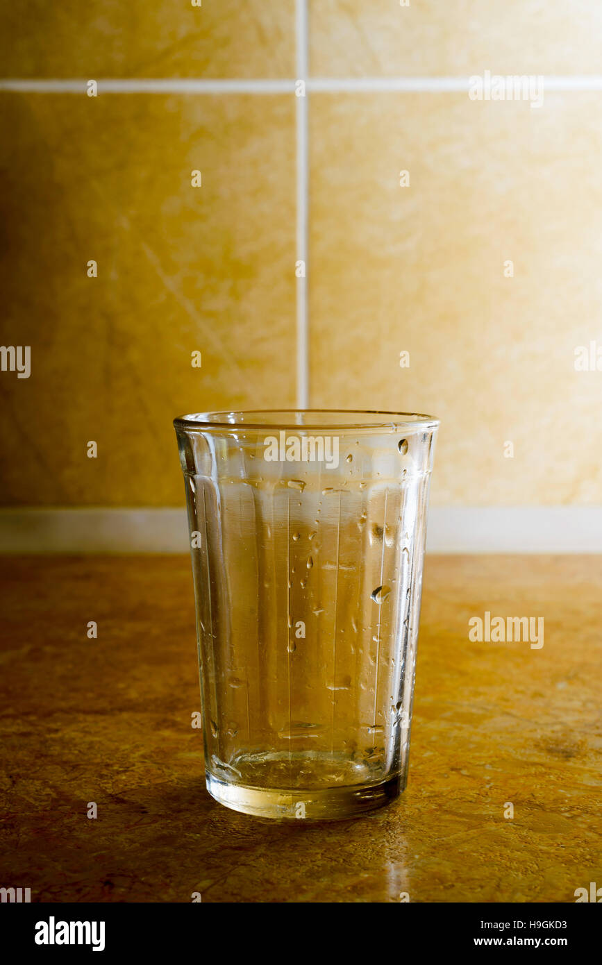 Empty glass with water drops in the kitchen Stock Photo - Alamy