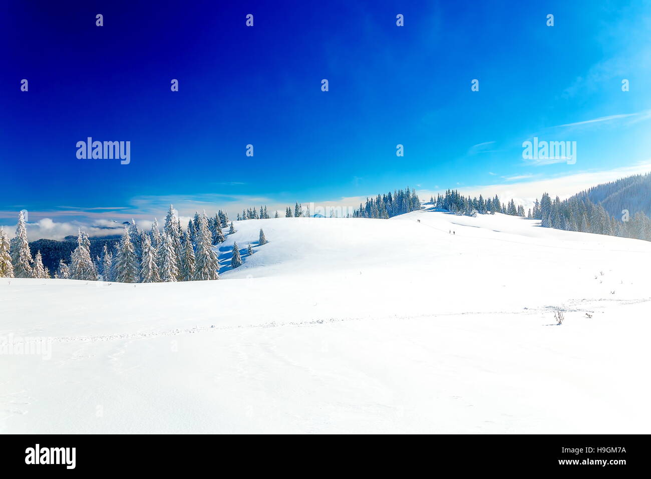Beautiful mountain landscape and snowy paths in the snow with tourists ...