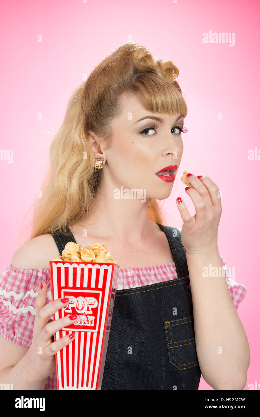 Pin up girl eating from a carton of popcorn Stock Photo - Alamy