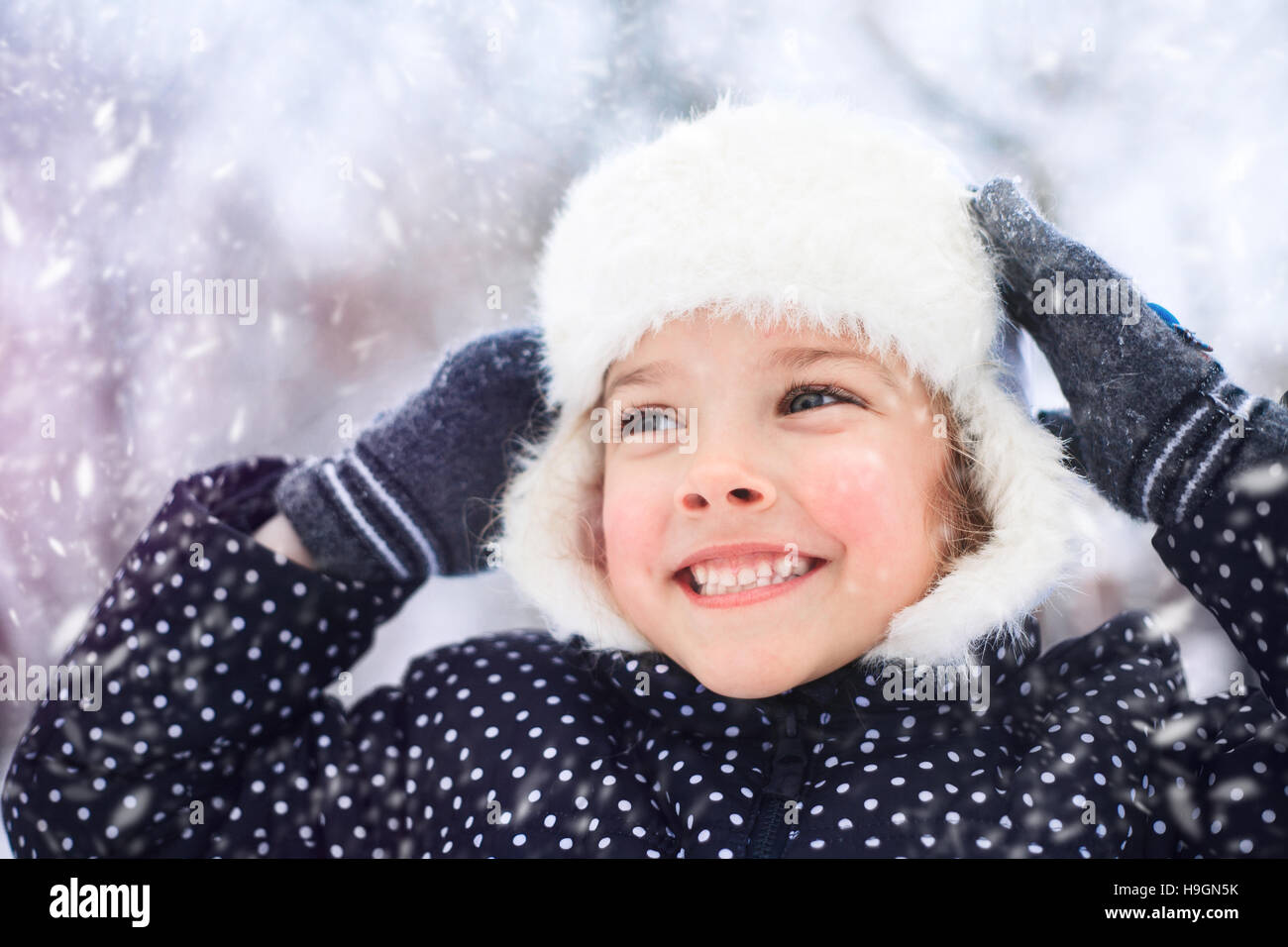 Portrait of a cute little girl in a snowy park during a snowfall Stock ...