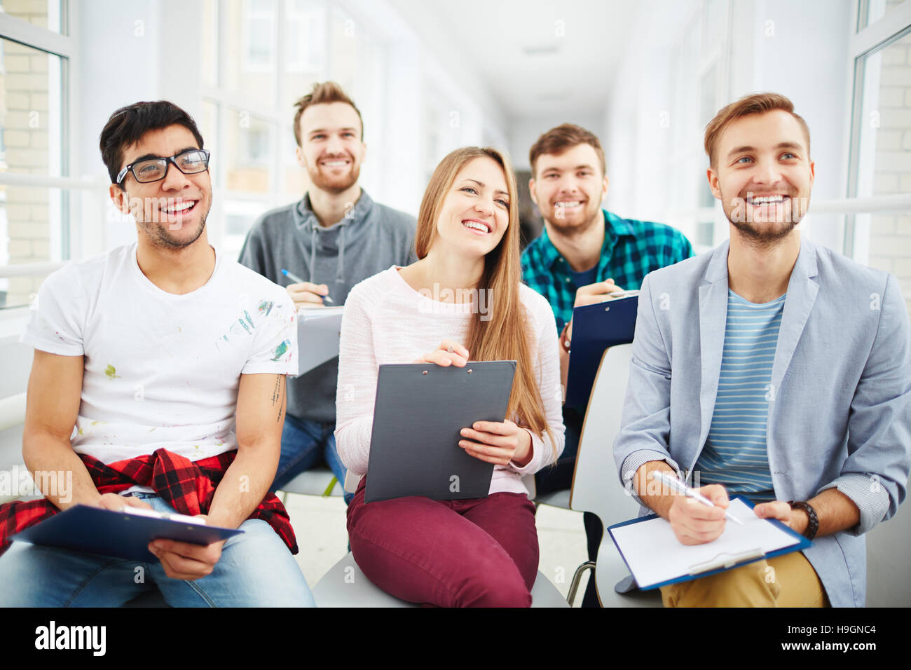 Happy groupmates looking at teacher during lecture Stock Photo - Alamy