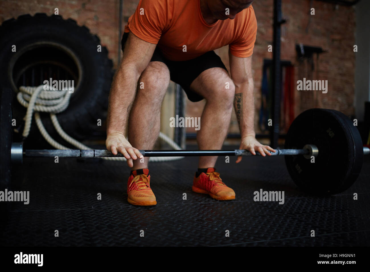 Athlete squatting while taking weight in gym Stock Photo - Alamy