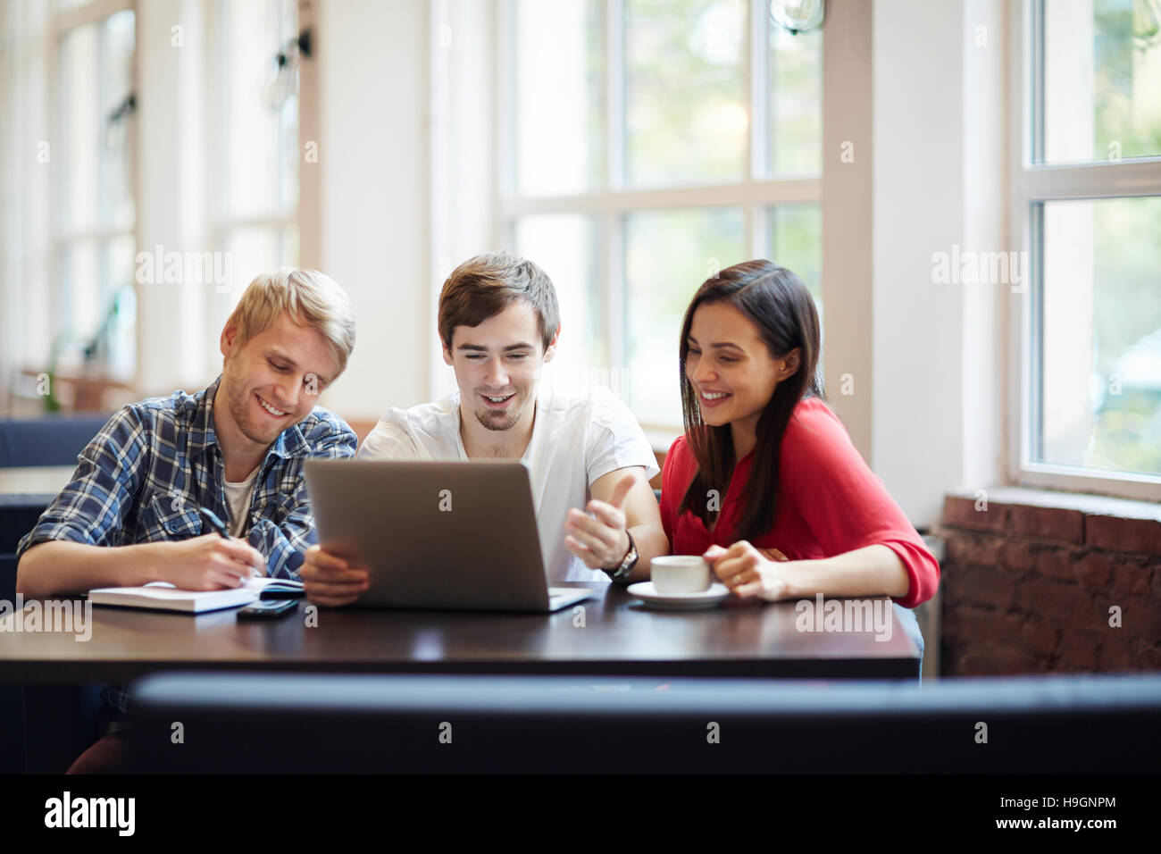 Teenage students brainstorming in front of laptop in classroom Stock ...