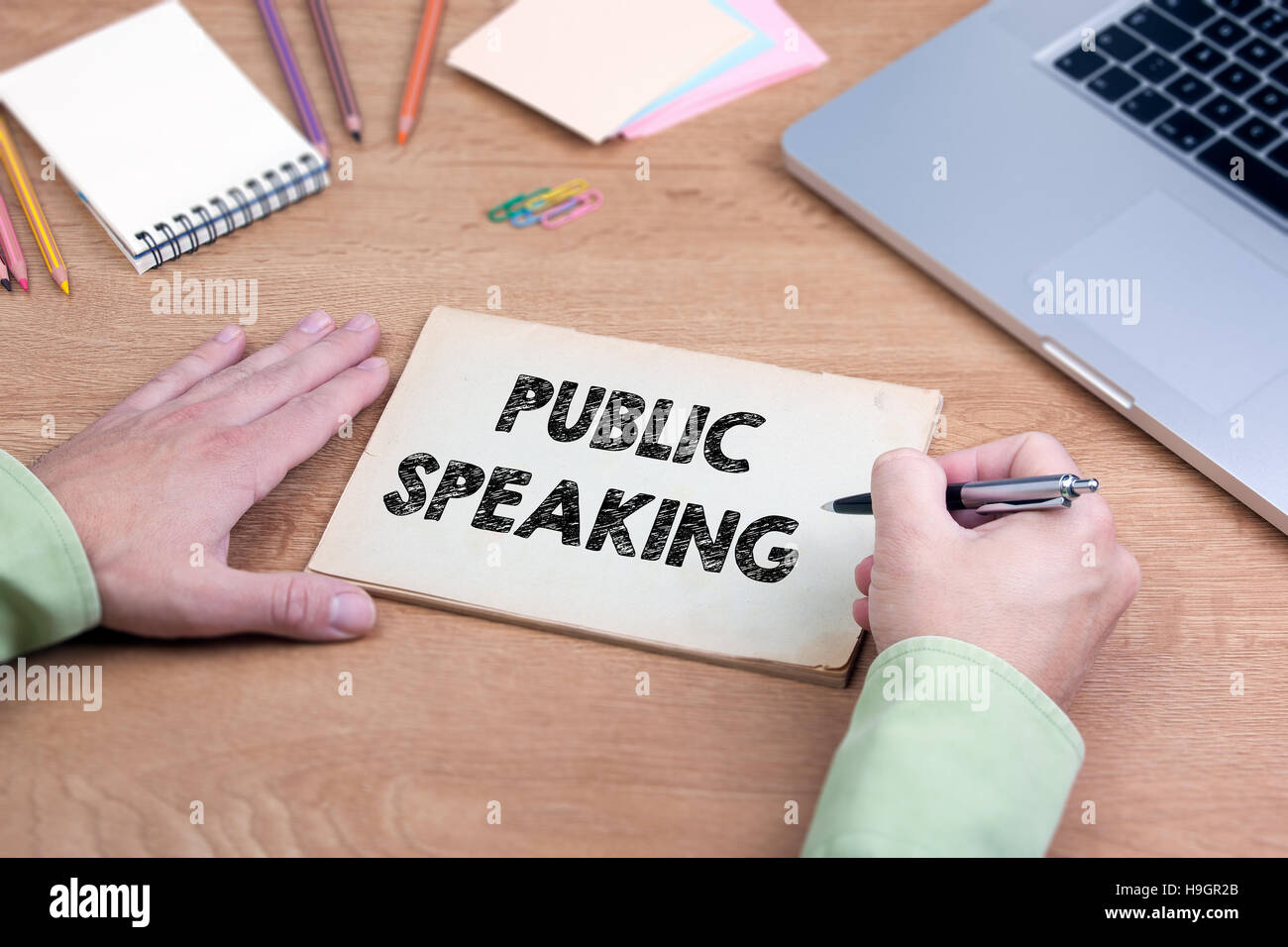 Hand writing Public Speaking. Office desk with a laptop and stationery ...