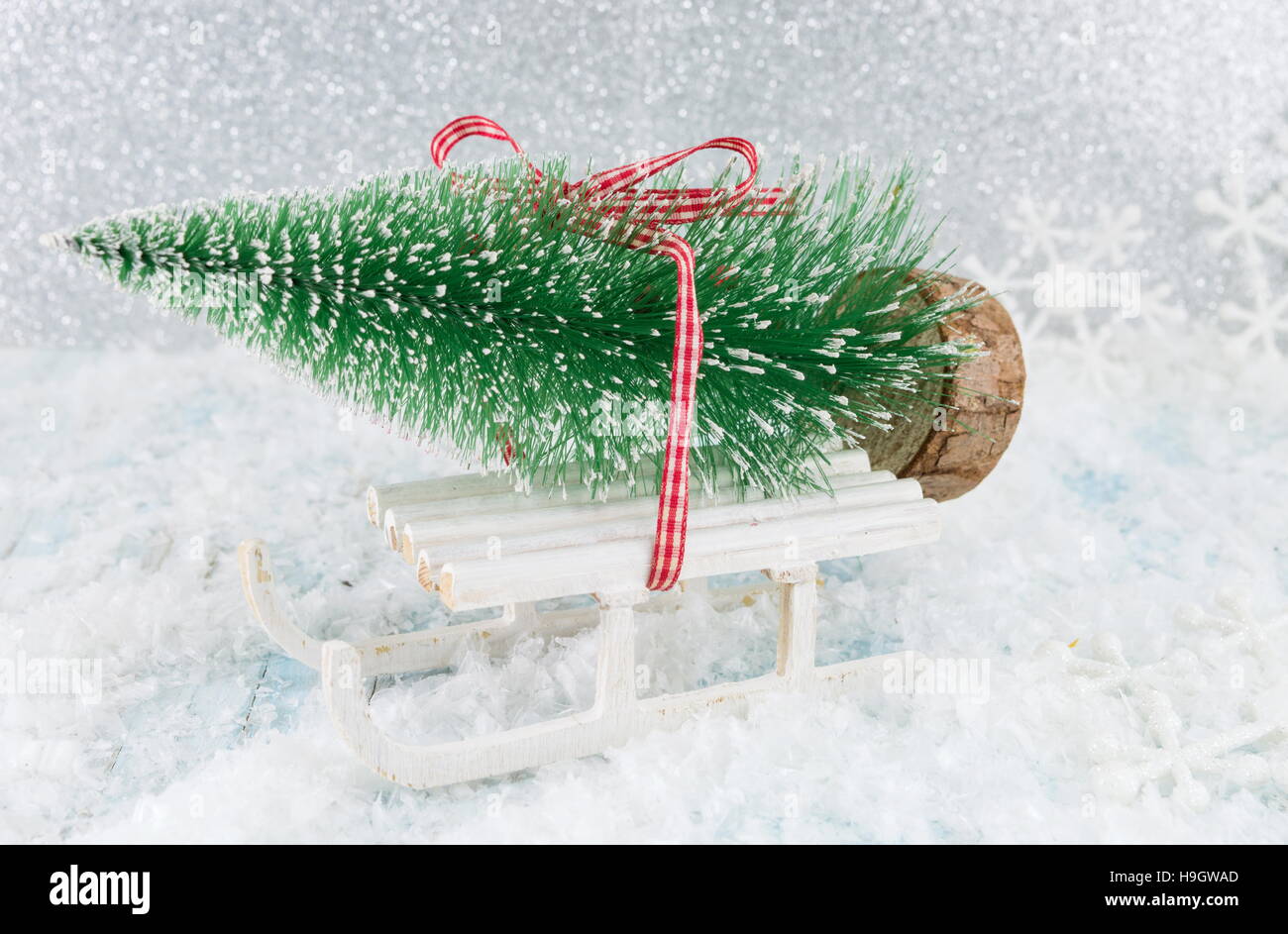 Small sleigh carrying a Christmas tree miniature Stock Photo - Alamy
