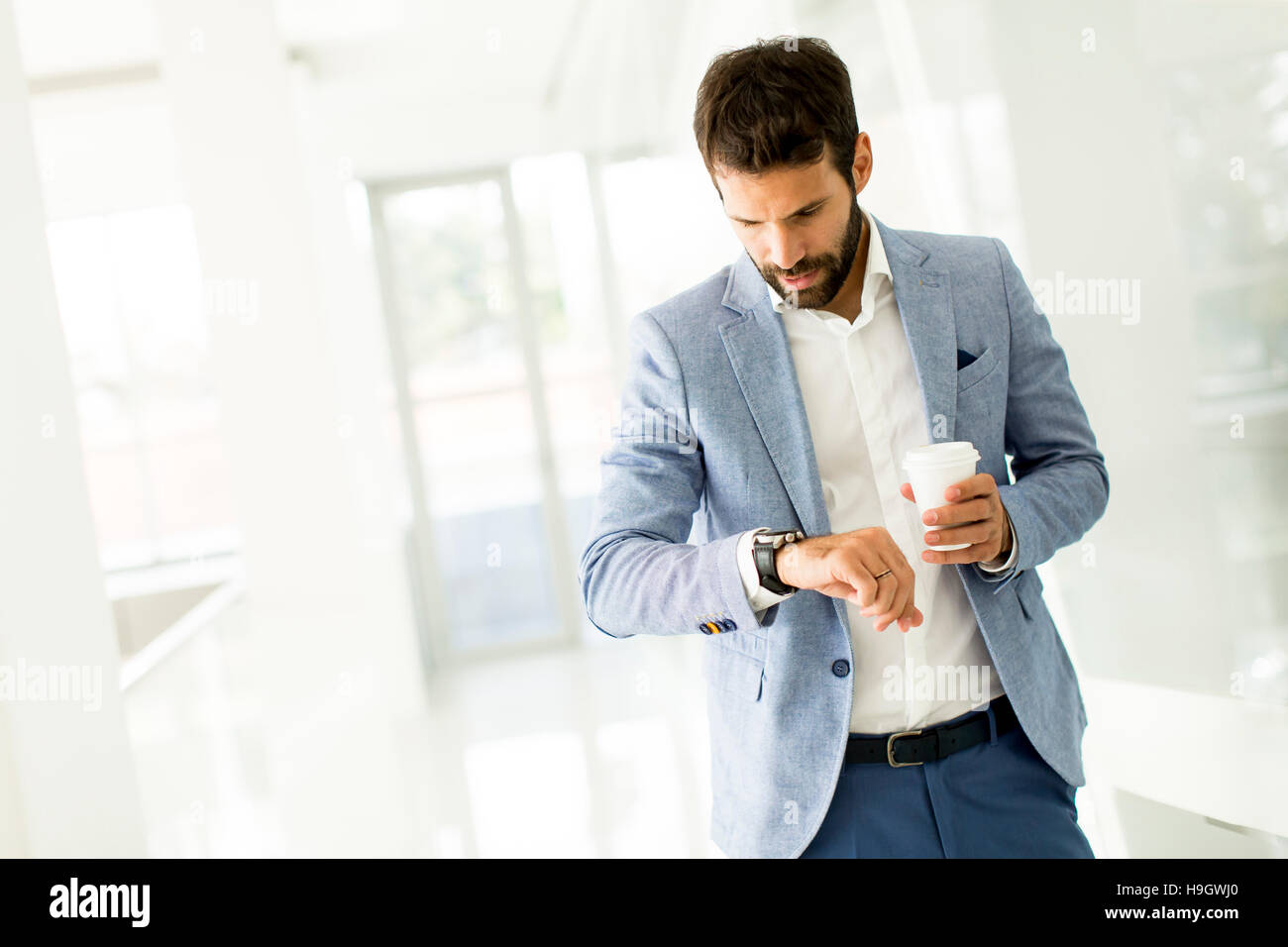 Modern businessman looking at his watch Stock Photo - Alamy