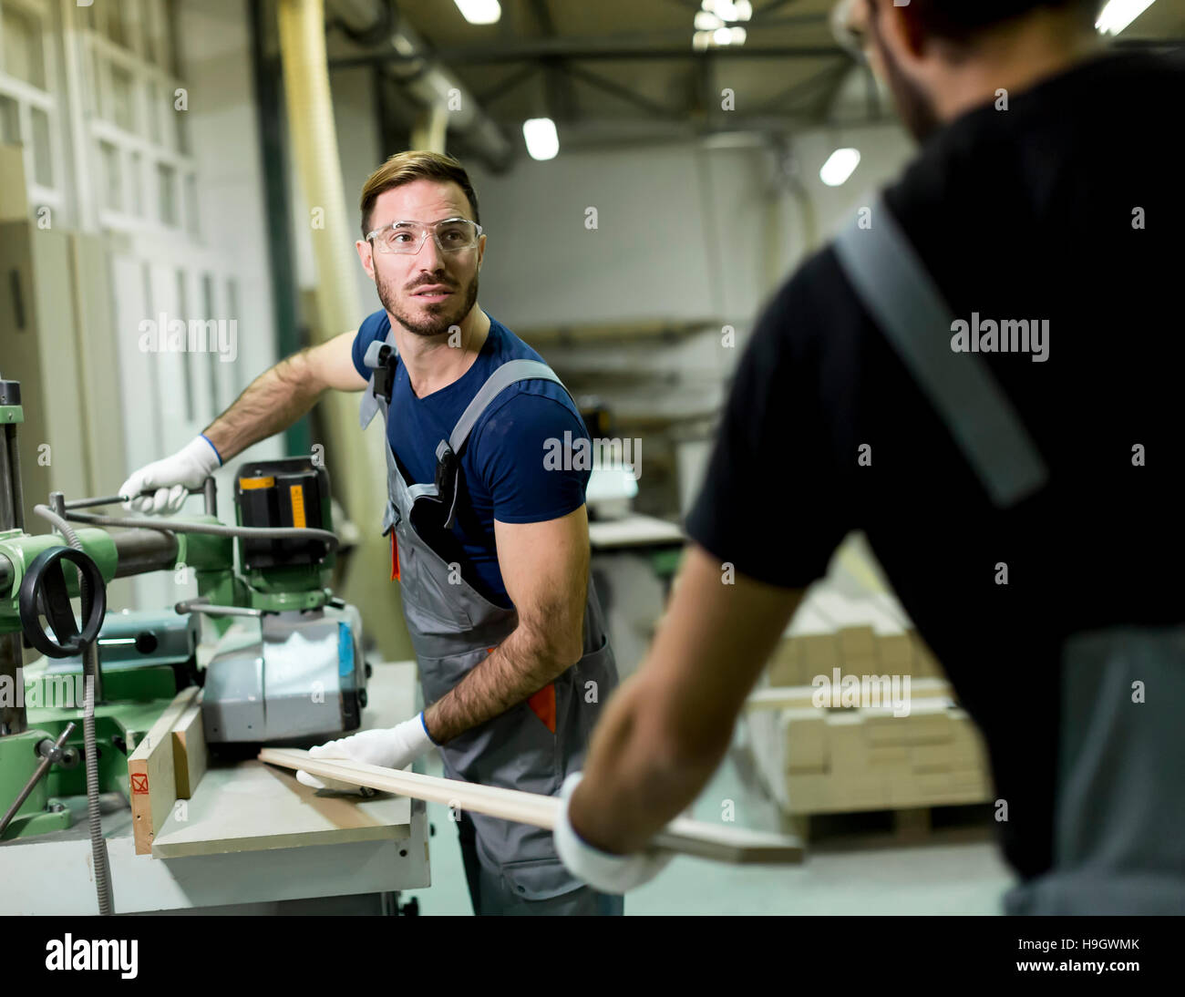 Young worker works in a factory for the production of furniture Stock ...