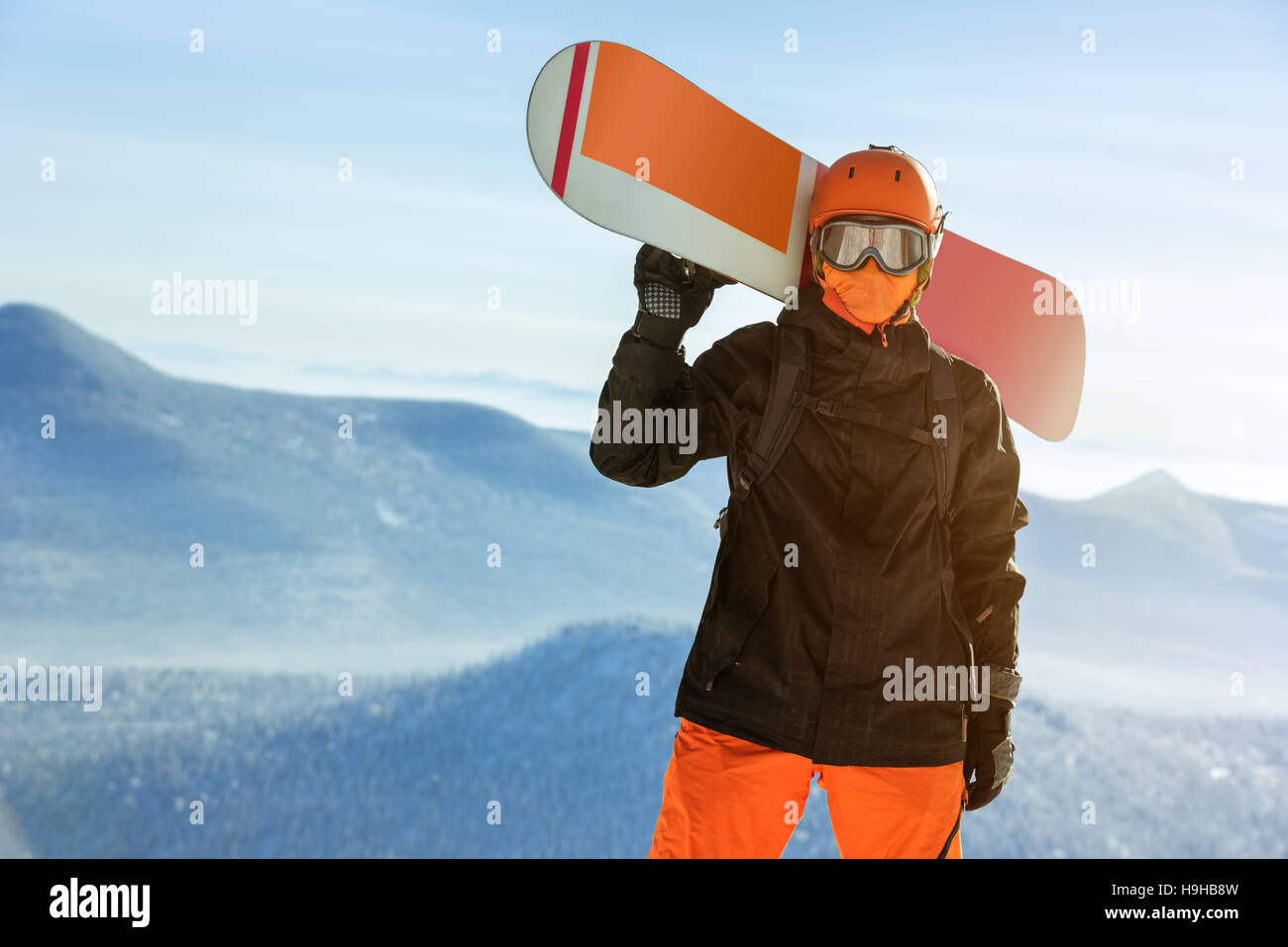 Snowboarder snowboard portrait mountain top orange Stock Photo - Alamy