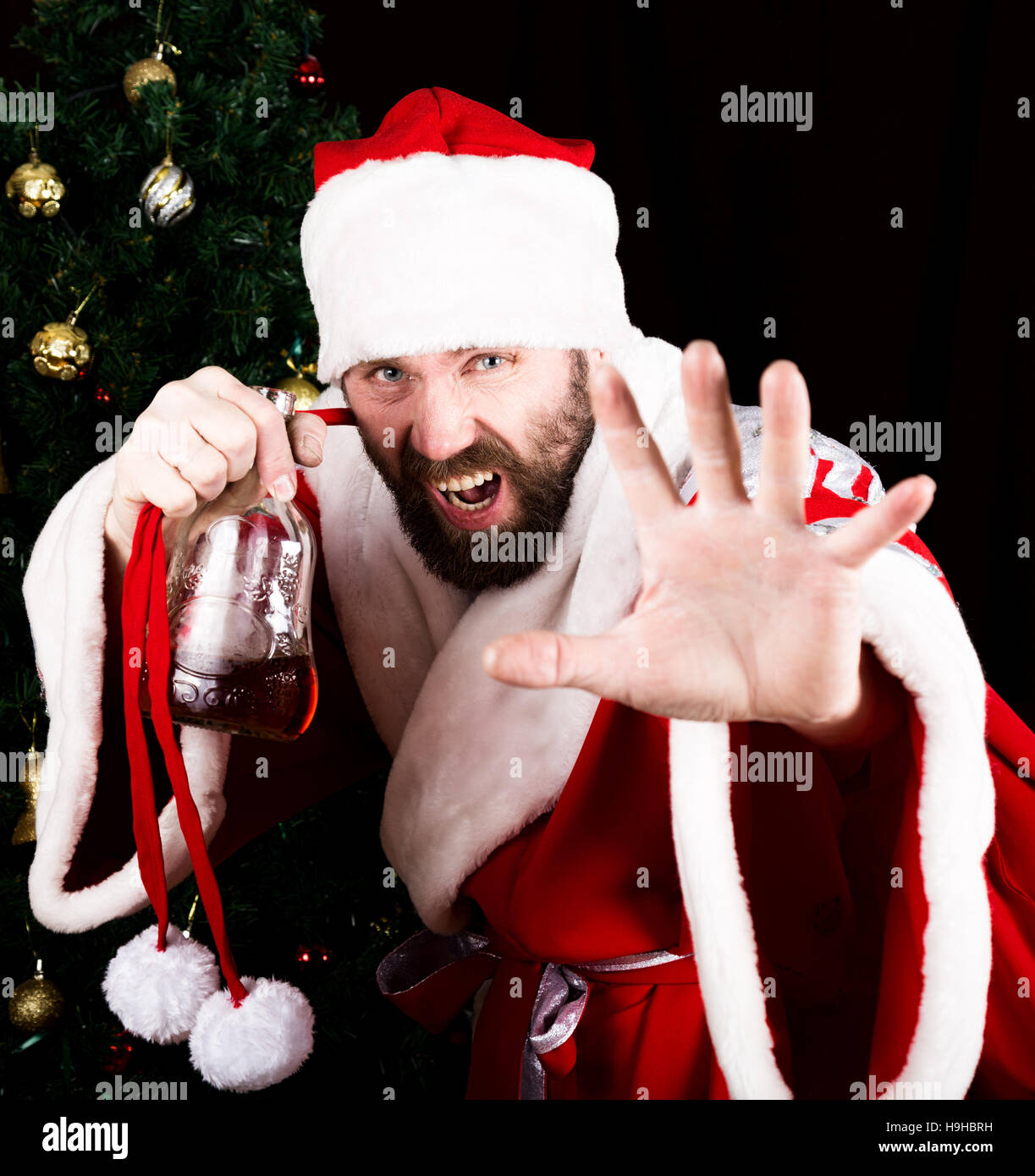 bad brutal Santa Claus smiling spitefully, drinking brandy from a ...