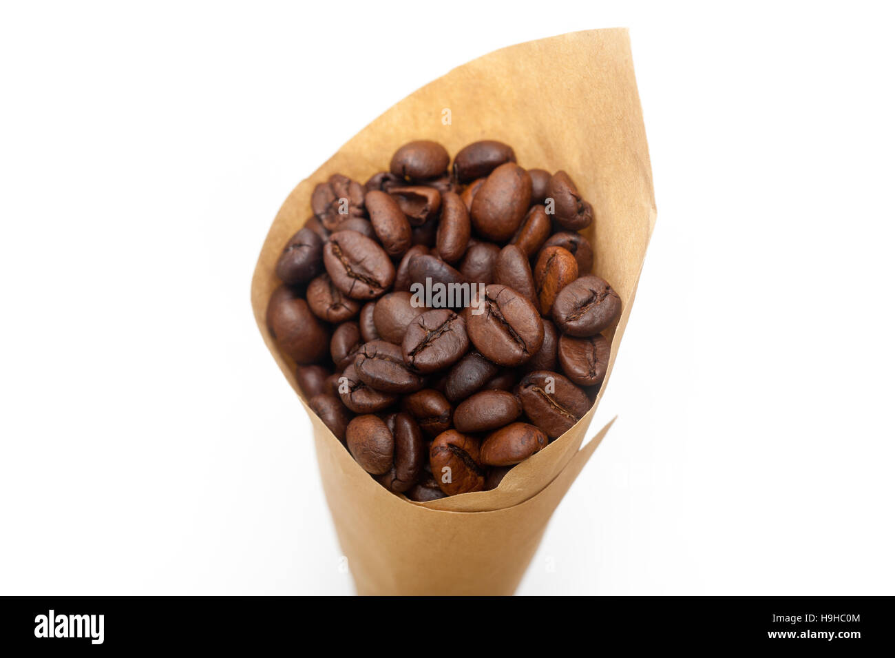 espresso coffee beans on a paper cone cornucopia over white background ...
