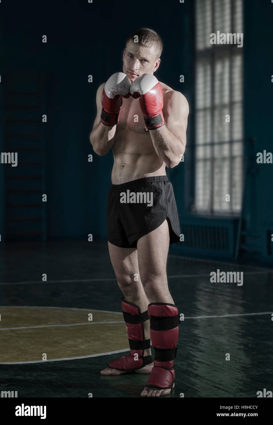 Young athletic man with boxing gloves and a rack Stock Photo - Alamy