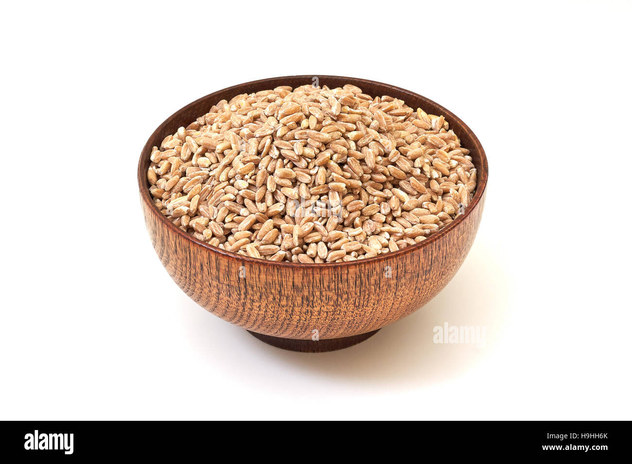 Spelt grain (dinkel wheat) in wooden bowl isolated on white background ...